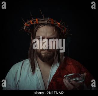 Jesus Christ smokes a cigarette wearing a crown of thorns and white ...