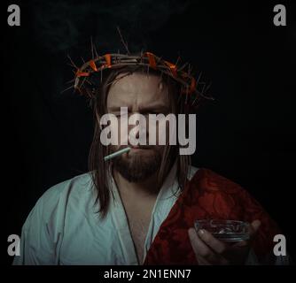 Jesus Christ smokes a cigarette wearing a crown of thorns and white ...