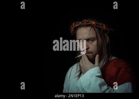 Jesus Christ smokes a cigarette wearing a crown of thorns and white ...