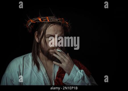 Jesus Christ smokes a cigarette wearing a crown of thorns and white ...