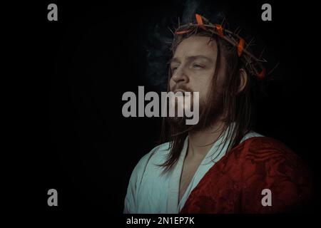 Jesus Christ smokes a cigarette wearing a crown of thorns and white ...