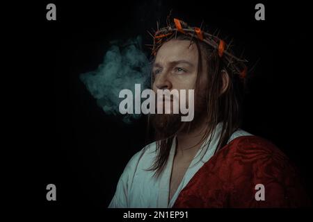 Jesus Christ smokes a cigarette wearing a crown of thorns and white ...