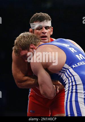 Artur Aleksanyan, of Armenia, in blue, wrestles with Ghasem Gholamreza ...