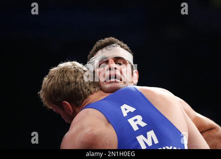 Artur Aleksanyan, of Armenia, in blue, wrestles with Ghasem Gholamreza ...