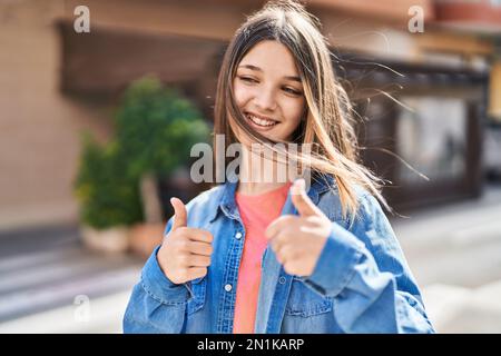 Okay. Cute teenager child girl making Ok gesture on yellow background ...