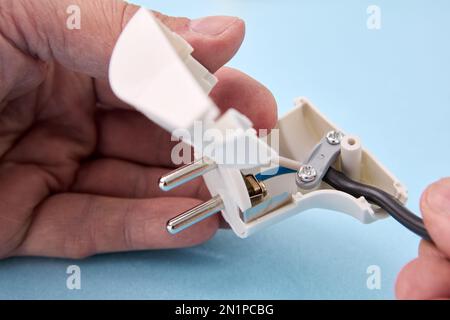 Electrical cord is connected to folding electric plug and secured with ...