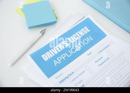 Driver's license application form and stationery on white table Stock ...