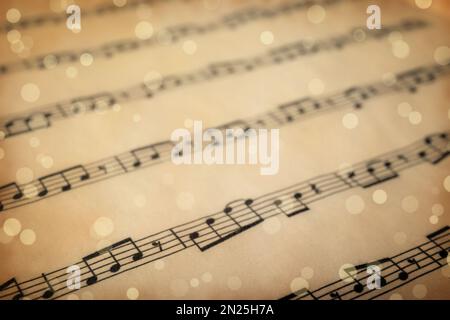 Old sheet with Christmas music notes as background, bokeh effect Stock ...