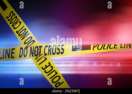 Yellow law enforcement tape isolating crime scene. Blurred view of city ...