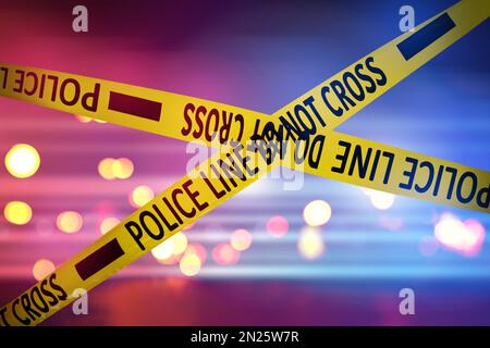 Yellow law enforcement tape isolating crime scene. Blurred view of city ...