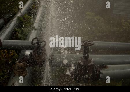 Water pouring out of broken pipe. Pipeline breakthrough. Boiler station ...