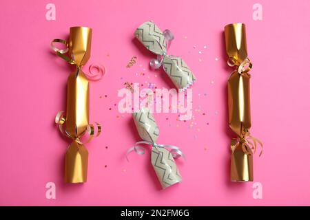 Open and closed Christmas crackers with shiny confetti on red ...