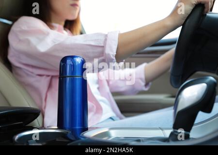 Blue thermos in holder inside of car Stock Photo - Alamy