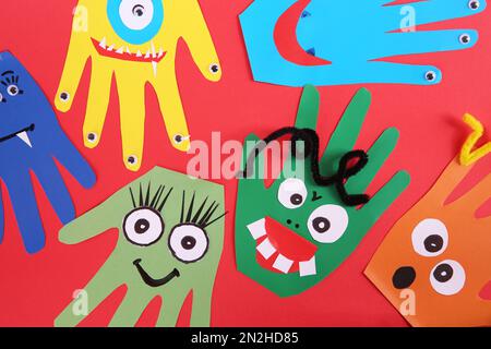 Funny hand shaped monsters on red background, flat lay. Halloween ...