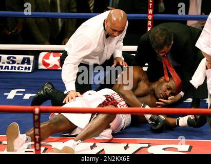 British boxer, Audley Harrison, center, is seen to by the referee, left ...