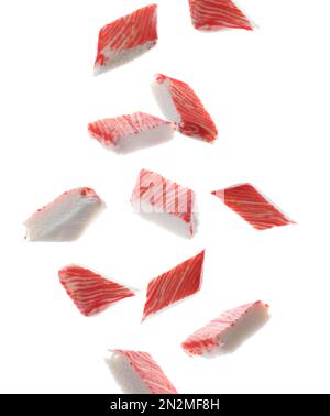 Cut fresh crab sticks falling on white background Stock Photo - Alamy