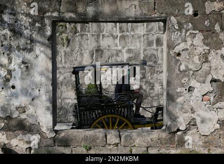 A horse drawn carriage known as a Kalesa being driven in downtown Cebu ...
