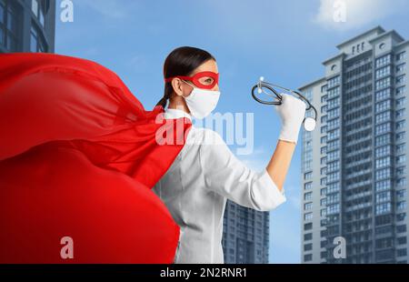 Doctor dressed as superhero on city background. Medical workers ...