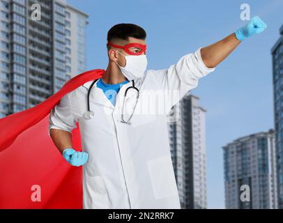 Doctor dressed as superhero on city background. Medical workers ...
