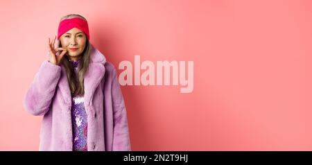 Fashion and shopping concept. Cunning asian senior woman in stylish ...