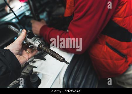 Removing stuck injector in diesel engine using press, closeup shot ...