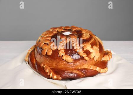 Korovai on tablecloth against grey background. Ukrainian bread and salt ...