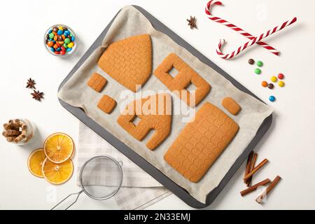 Parts of gingerbread house and ingredients for decoration on white ...