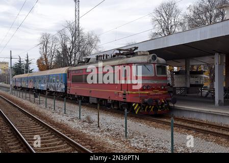 Skoda Type 44 electric locomotive with passenger train at Septemvri ...