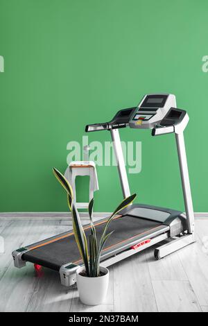 Modern treadmill near green wall Stock Photo - Alamy