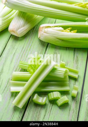 Pile of celery ribs on green wooden table. Healthy food background ...