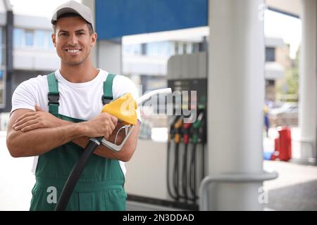 Worker with fuel pump nozzle at modern gas station Stock Photo - Alamy