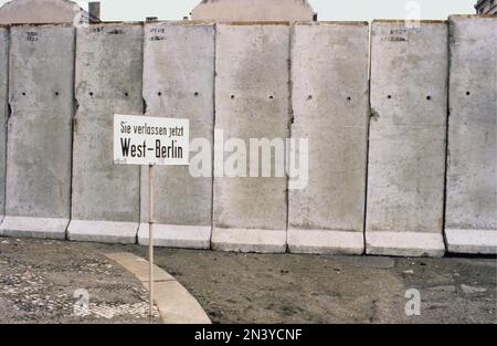 The Berlin Wall. A guarded concrete barrier that encircled West Berlin ...