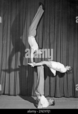 1940s acrobatic show. The three acrobats practice their balance act ...