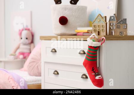 Stocking with presents hanging on drawer in children's room, space for ...