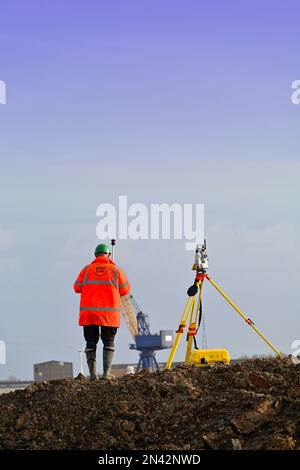 A surveyor using a theodolite to landscape the area before developing ...