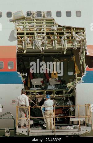 Two inspectors look at the severely damaged United Airlines 747 at ...