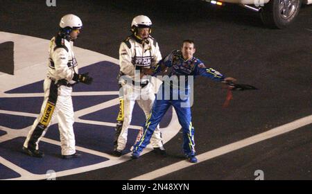 Driver Kyle Busch is restrained by a NASCAR official as Busch throws ...