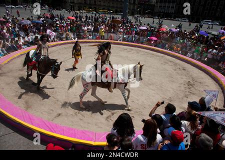 Native American performers dressed in traditional costumes dancing at ...