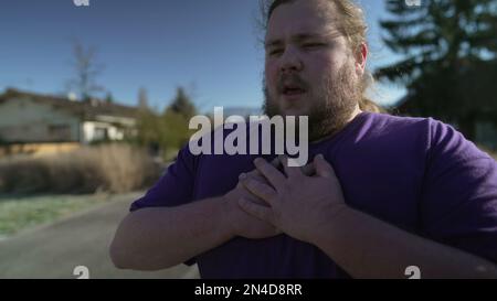 One young fat man having chest pain. Overweight person with panic ...