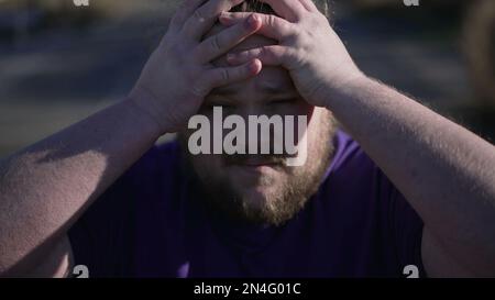 Suffering overweight man feeling headache rubbing eyes standing on ...