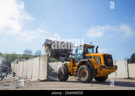 Front loader with scrap handling grapple bucket moving forward and ...