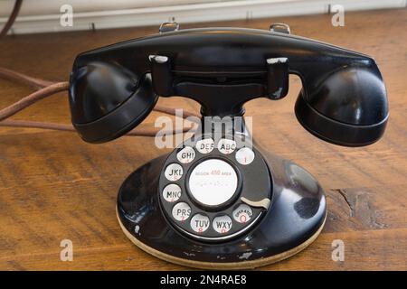 Vintage 1800s bakelite rotary dial telephone on top of desk inside an ...