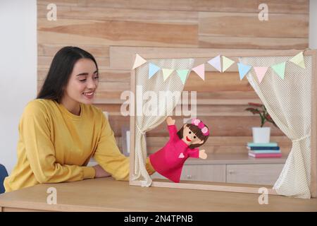 Happy woman performing puppet show at home Stock Photo - Alamy