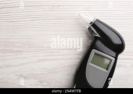 Modern breathalyzer with blank screen on white marble table, top view ...