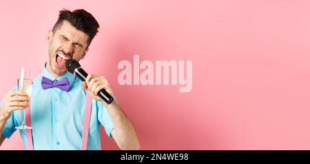 Party and festive events concept. Drunk funny guy singing in microphone ...