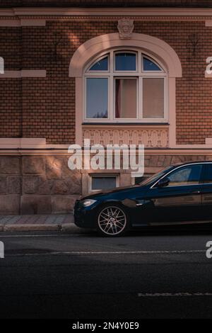 A vertical shot of a black BMW in the street Stock Photo - Alamy