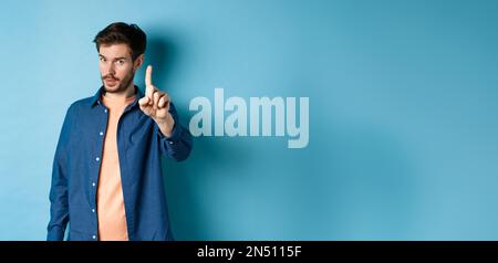 Image of young man give warning, teaching a lesson, raising one finger ...