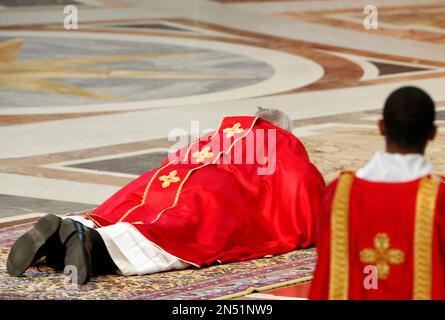 Pope Francis lays prostrate on the floor in prayer before presiding ...