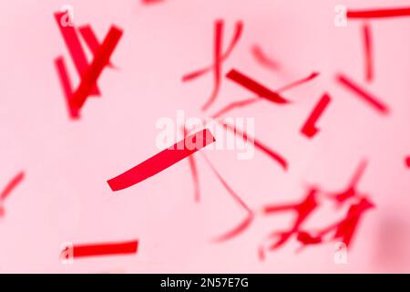 Shiny red confetti falling down on light blue background Stock Photo ...
