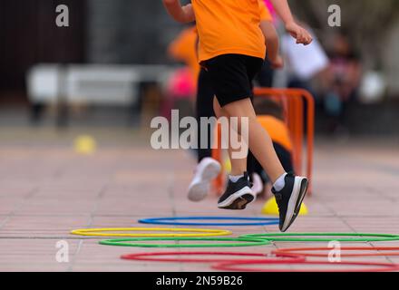 Competitive active game, children jump over obstacles Stock Photo - Alamy